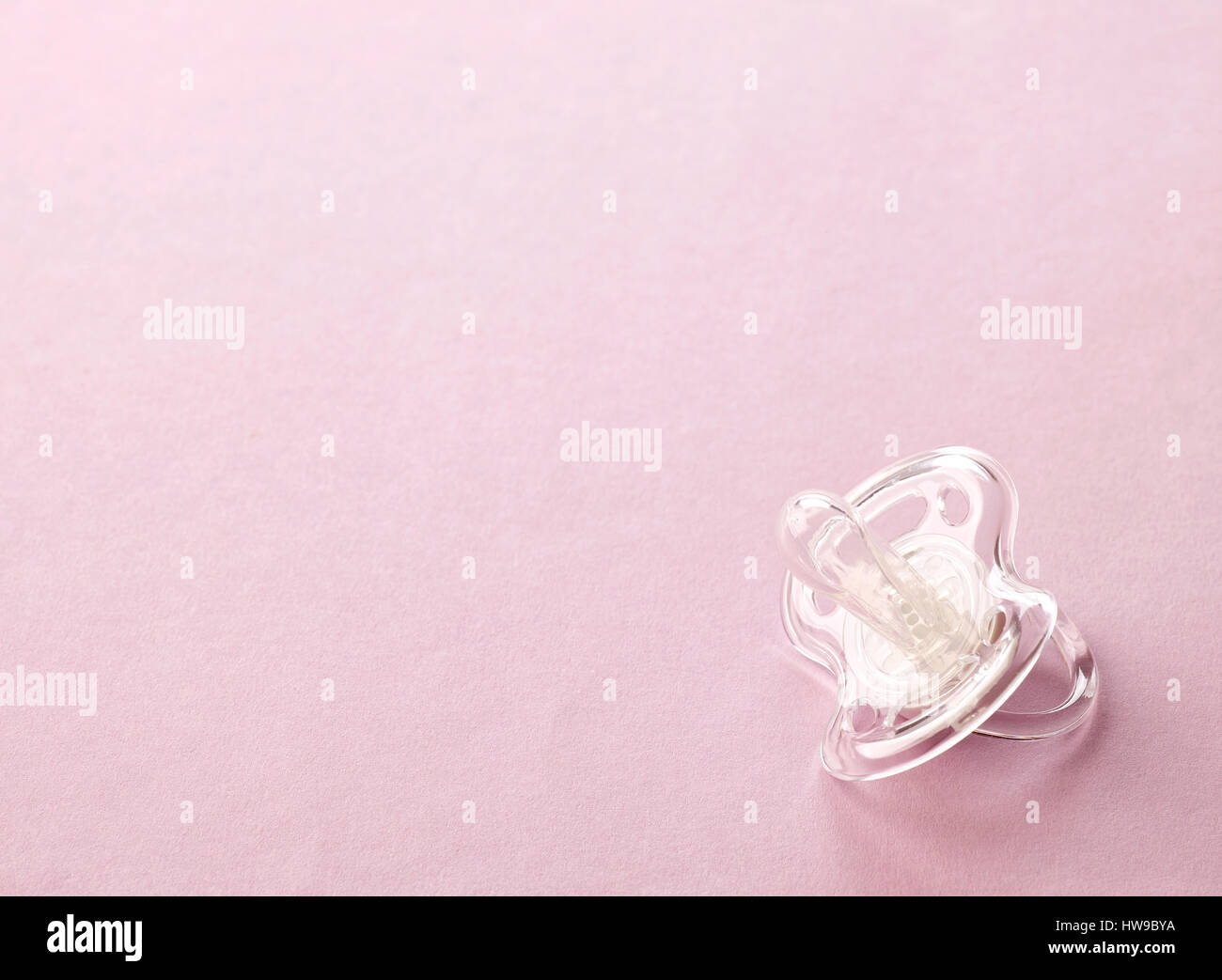 transparent pacifier on pink paper background Stock Photo - Alamy