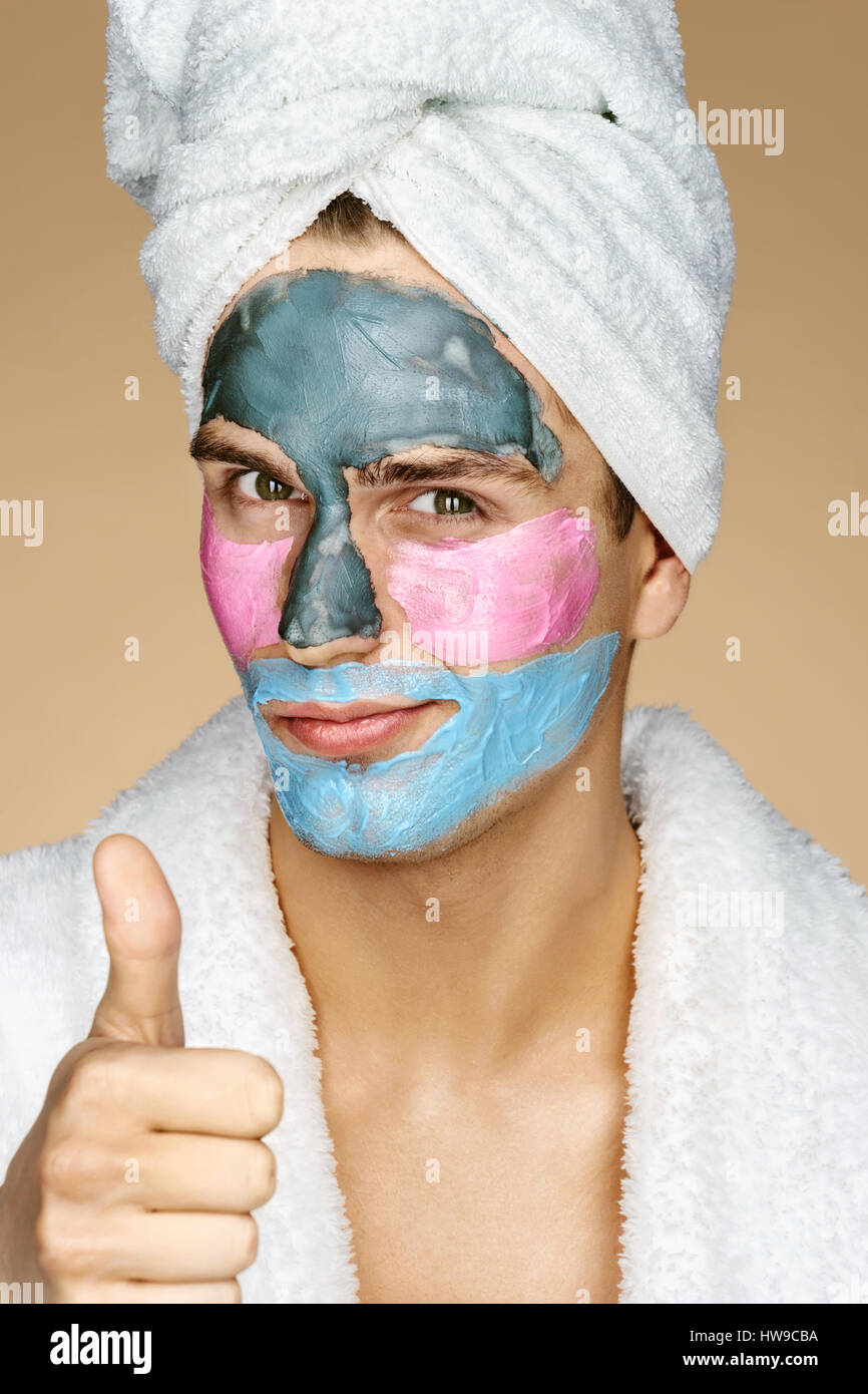 Funky face mask. Handsome man with different face masks shows thumbs up ...