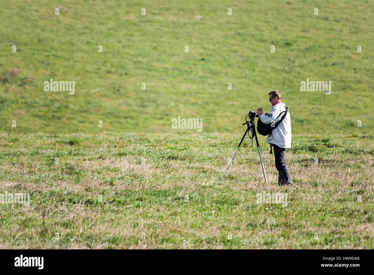 photographer working in the field with tripod Stock Photo - Alamy