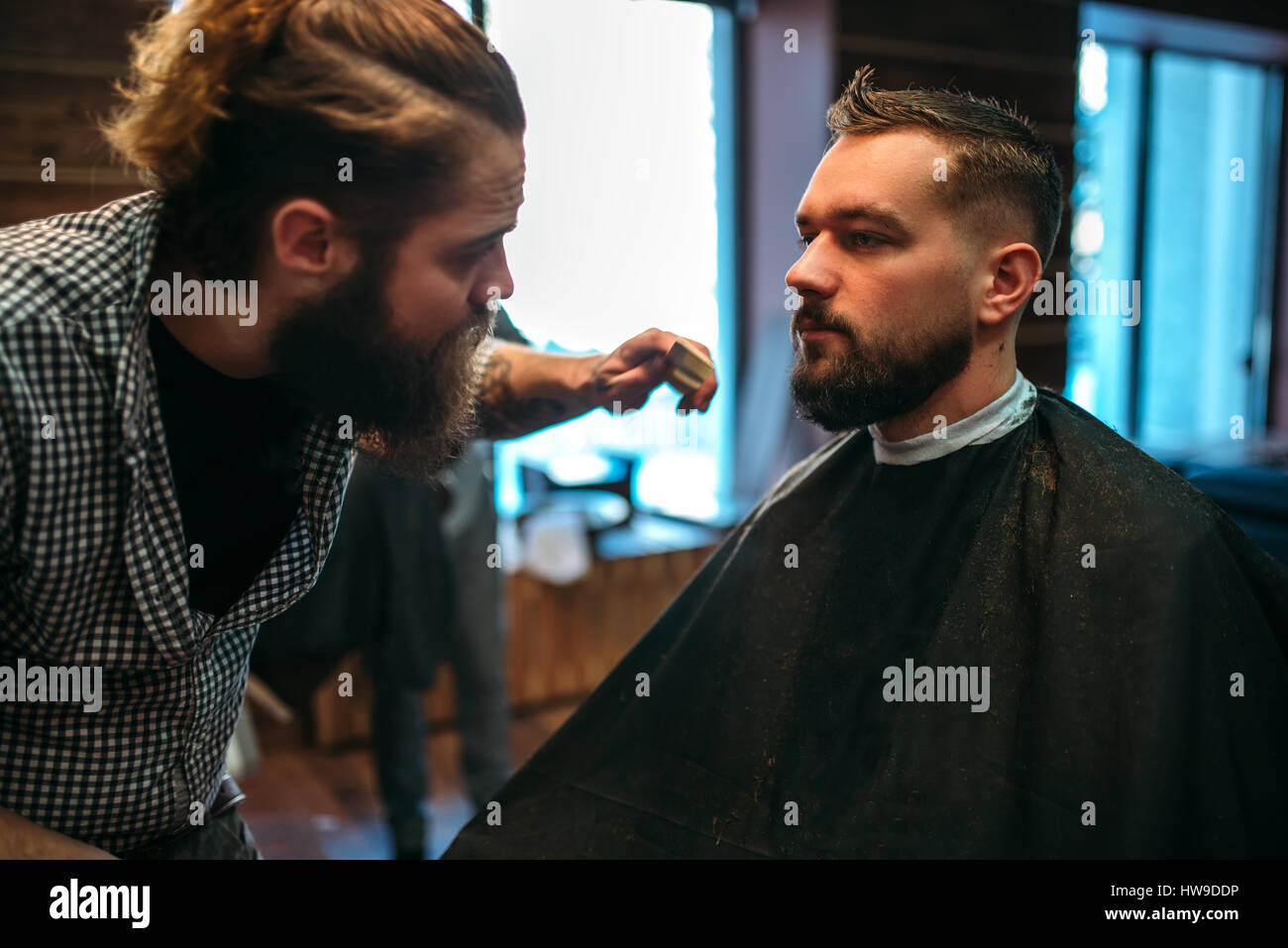 Barber styling mustache and beard at the barbershop. Hairdressing ...