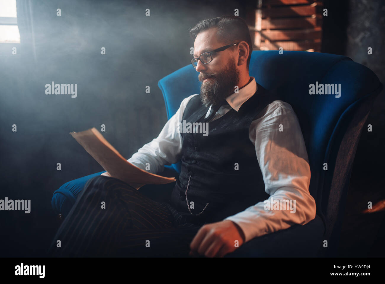 Seriuos bearded writer in glasses reads handwritten text against the ...