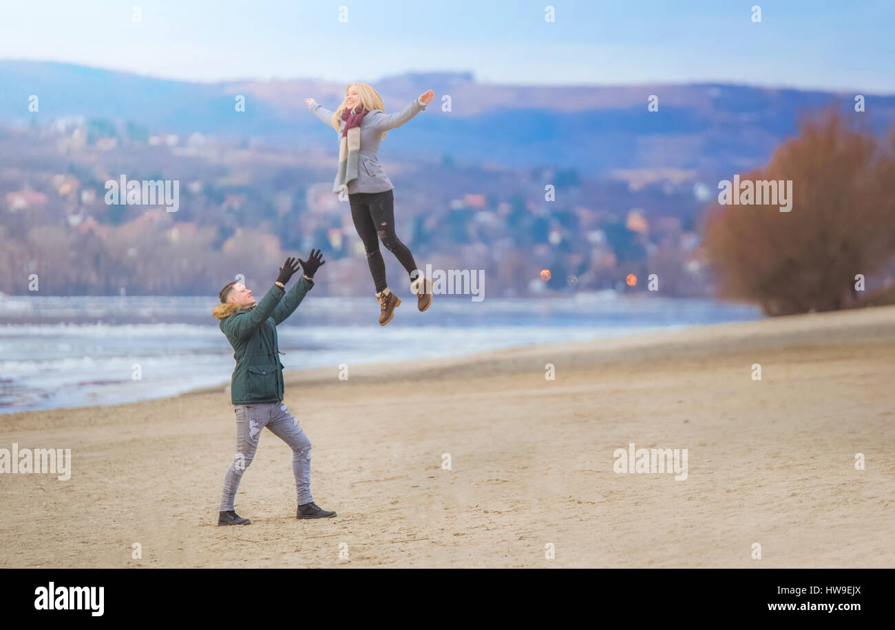 Young man throwing his girlfriend high in the air Stock Photo - Alamy