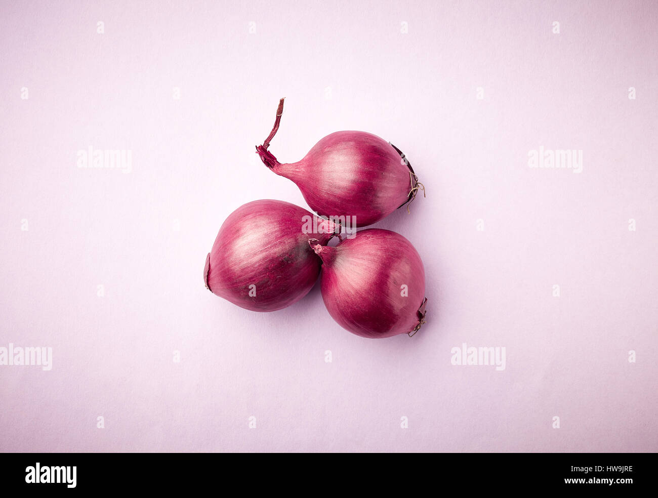 three red onions on purple background, top view Stock Photo - Alamy
