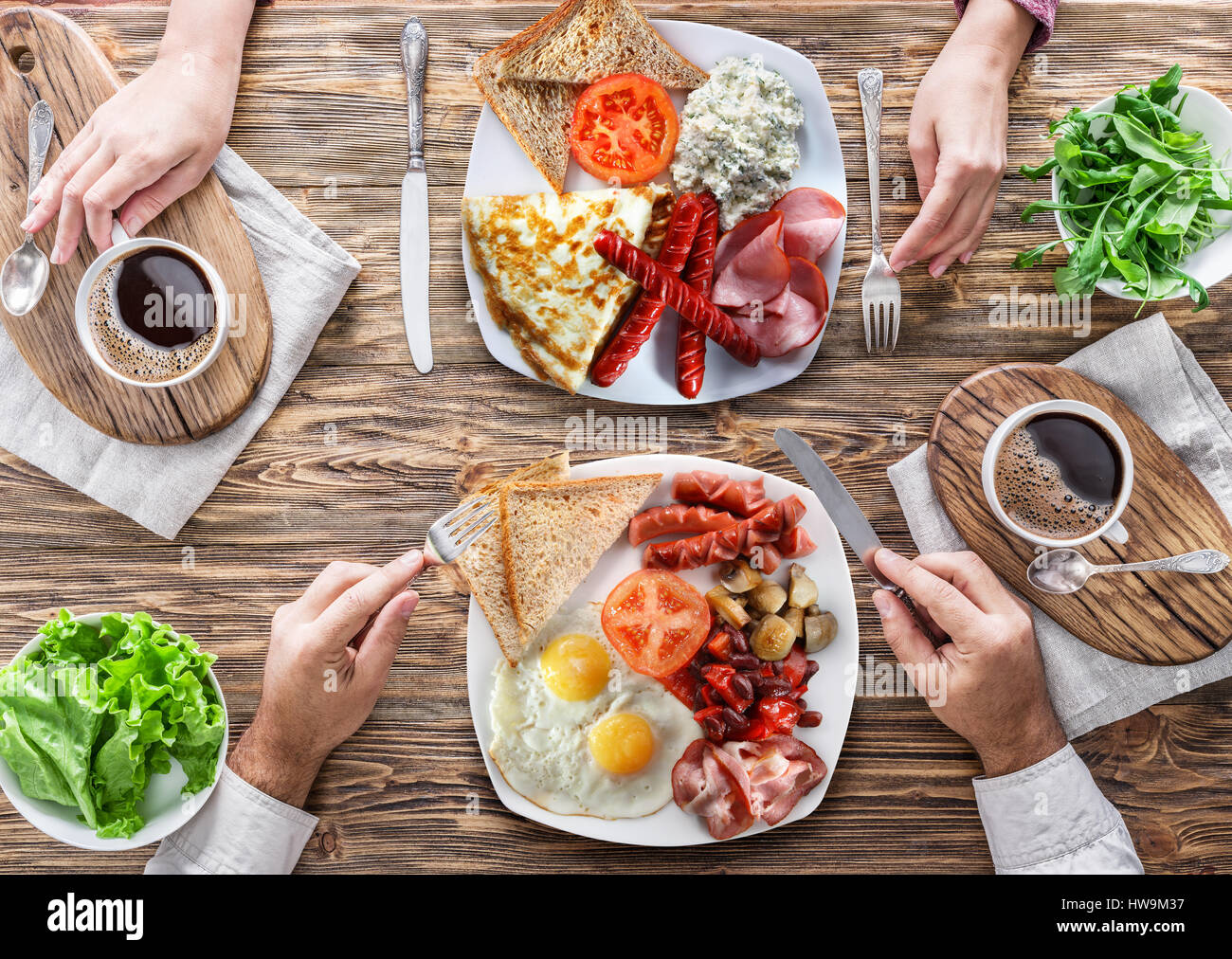 Traditional breakfast at home. Top view of table and people who having ...
