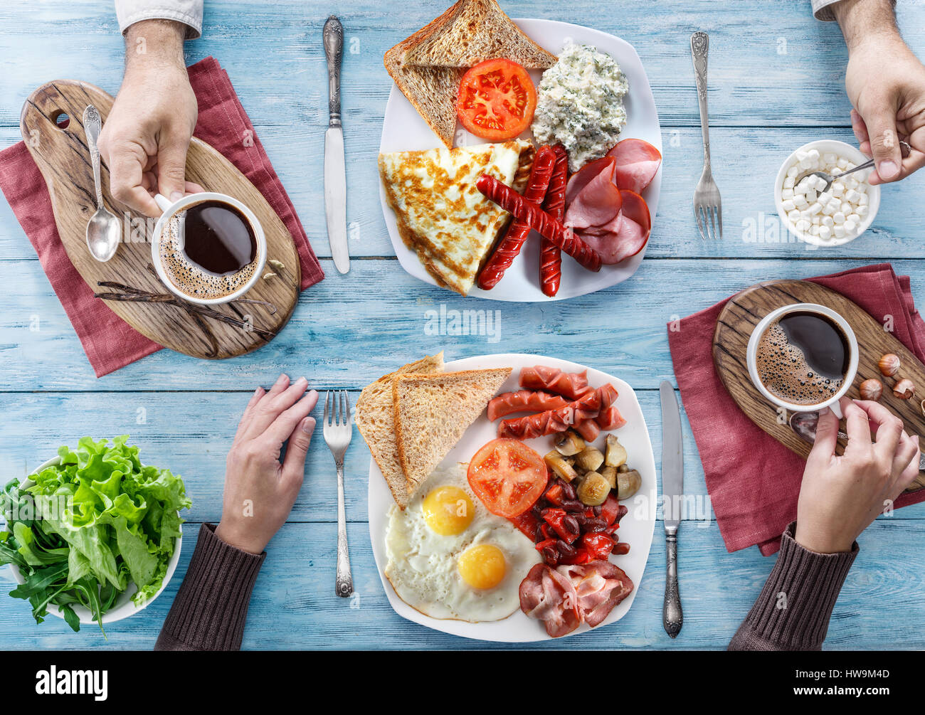 Traditional breakfast at home. Top view of table and people who having ...