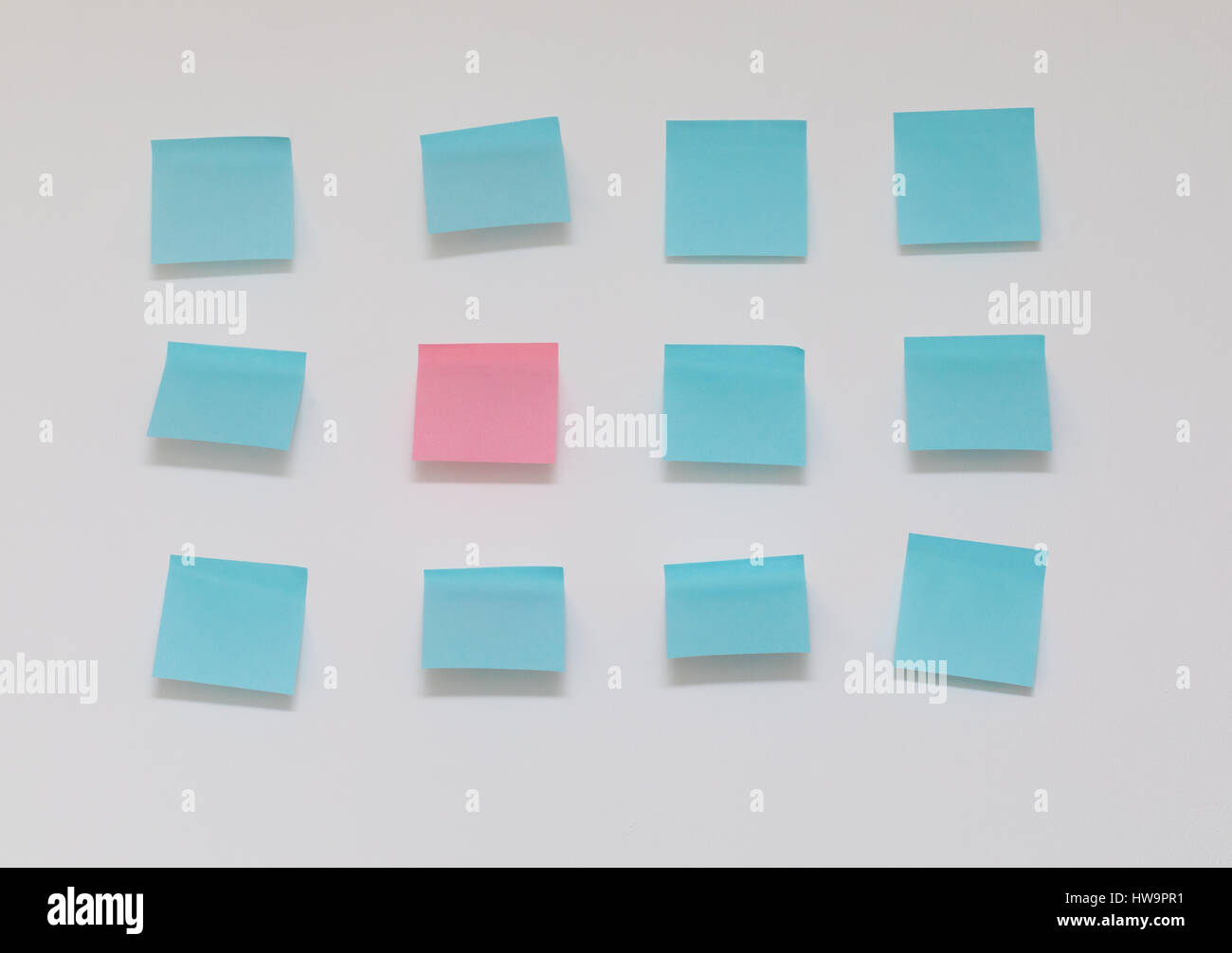 Single pink post it note in sea of blue post it notes Stock Photo - Alamy