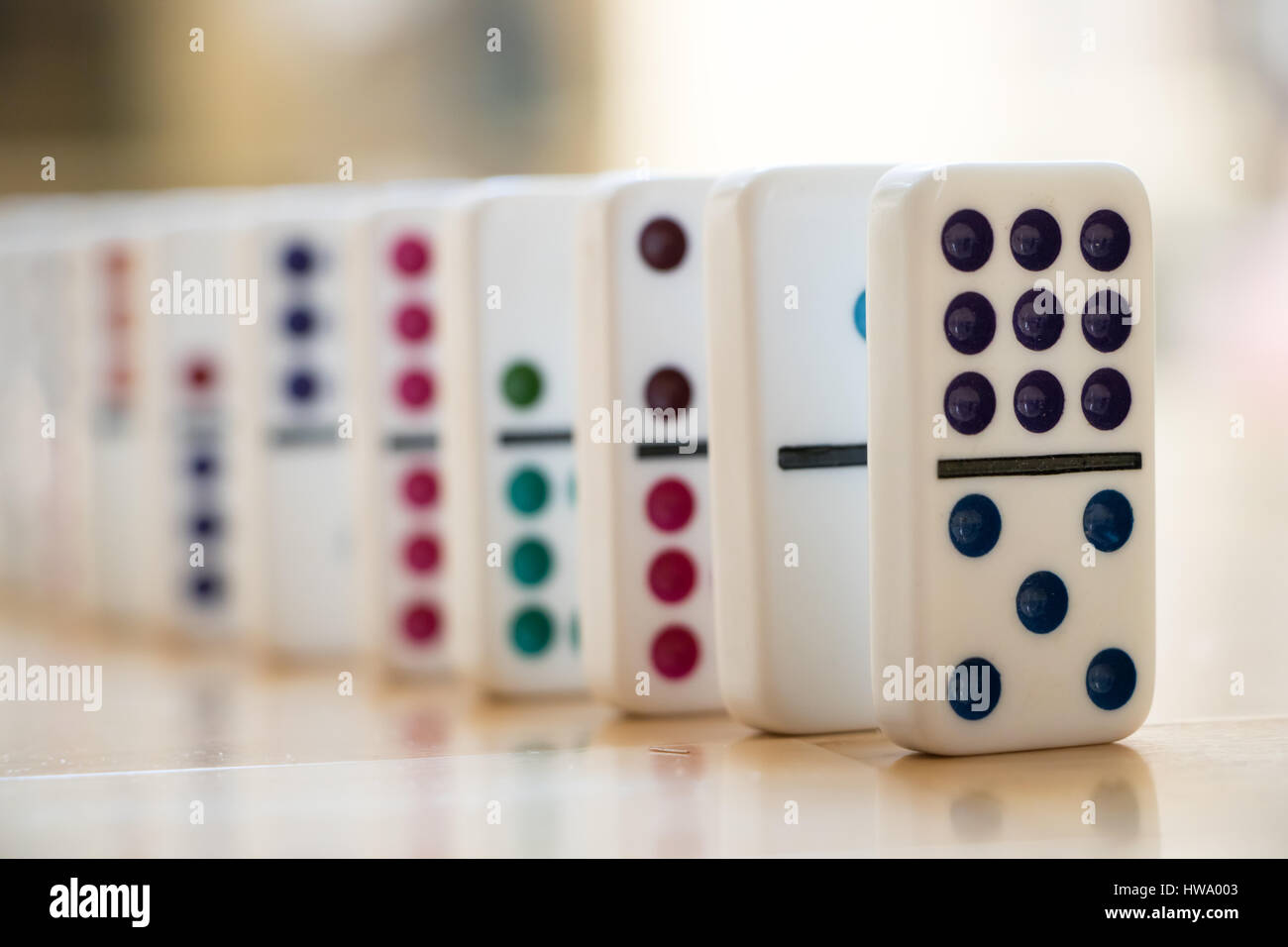 Straight Line of Colorful Dominoes on Wooden Floor Stock Photo - Alamy