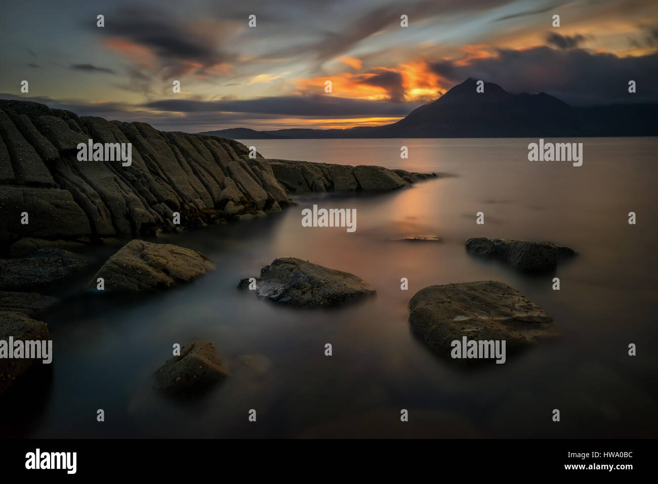 Rocky coastline of Loch Scavaig with Cuillin Mountains in background ...