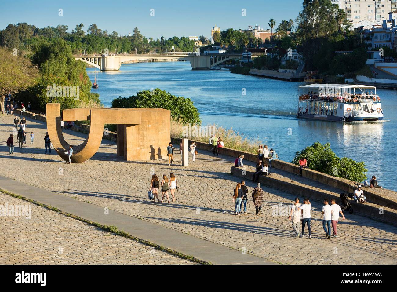 Spain, Andalucia, Sevilla, people walking by the riverside of the ...