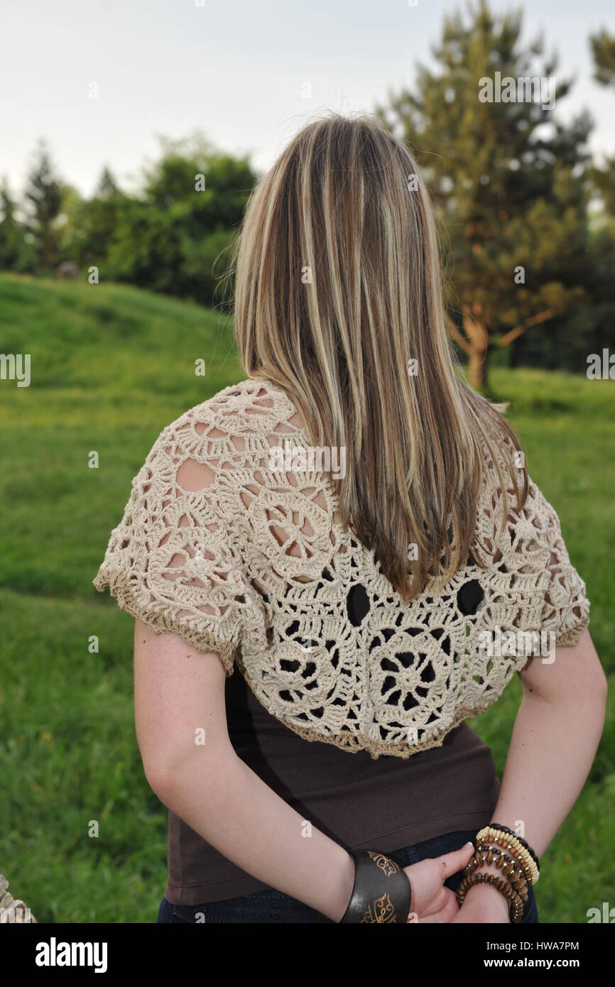 Young beautiful woman in knitted handmade clothes at park. Model ...