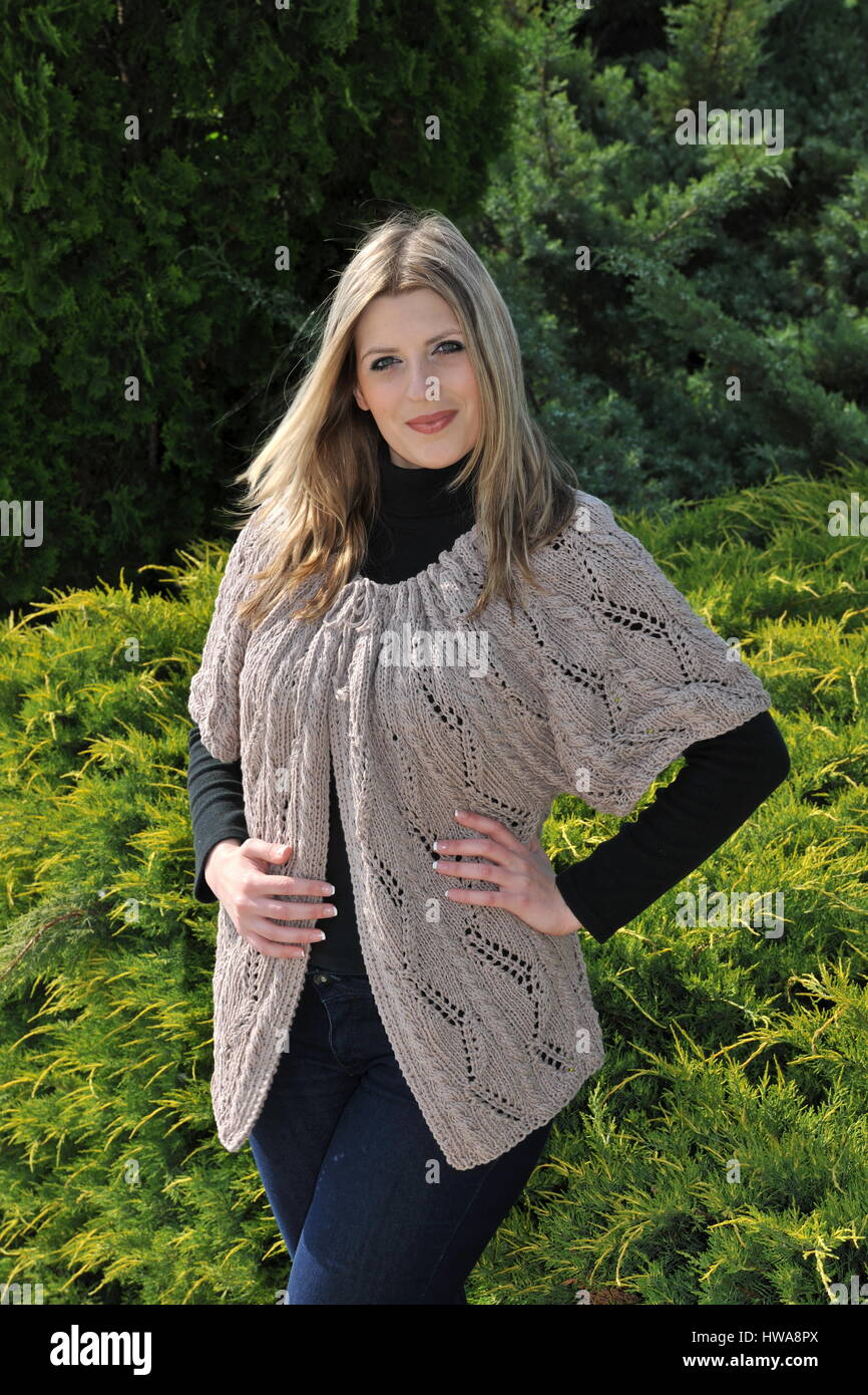 Young beautiful woman in knitted handmade clothes at park. Model ...