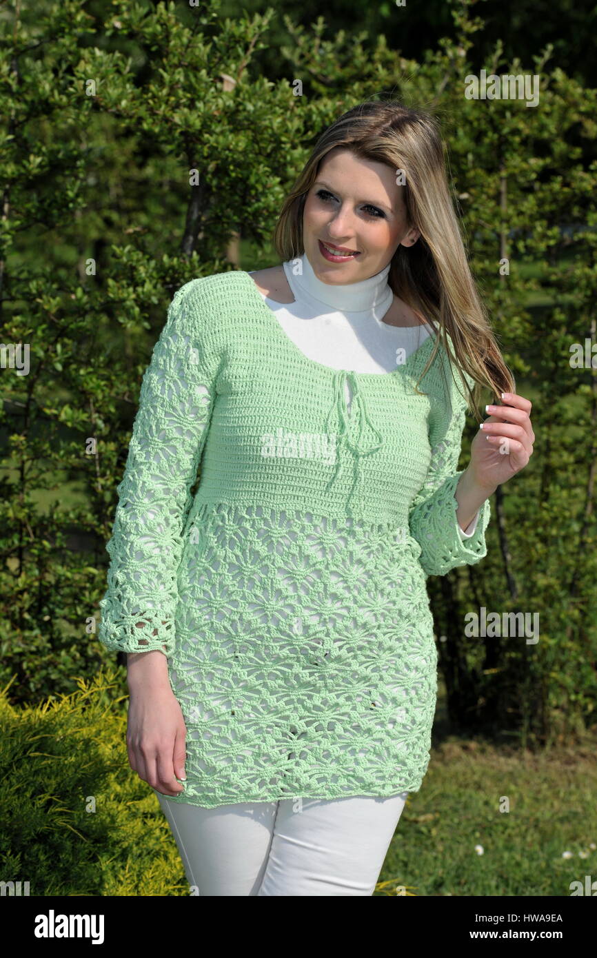 Young beautiful woman in knitted handmade clothes at park. Model ...