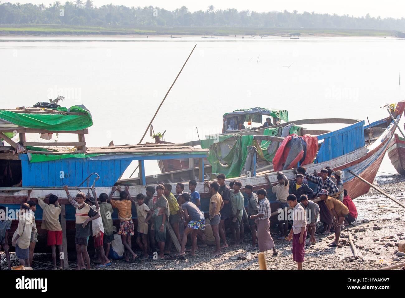 Myanmar, Rakhine State, Mrauk-U, group of men moving a boat Stock Photo ...