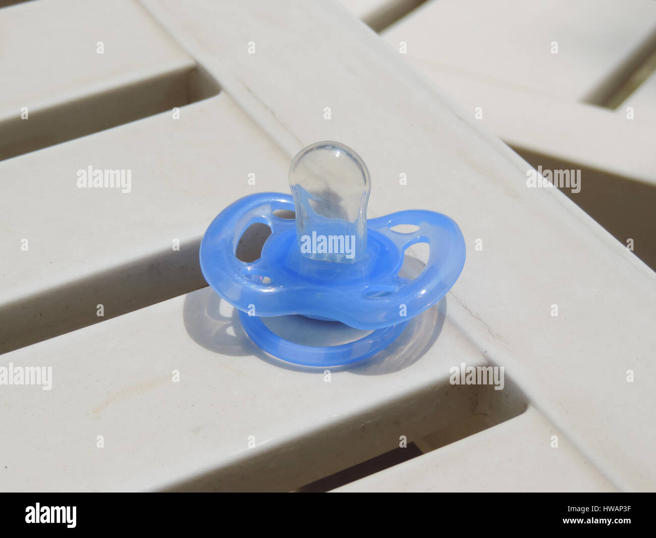 An isolated blue baby pacifier on the plastic surface Stock Photo - Alamy