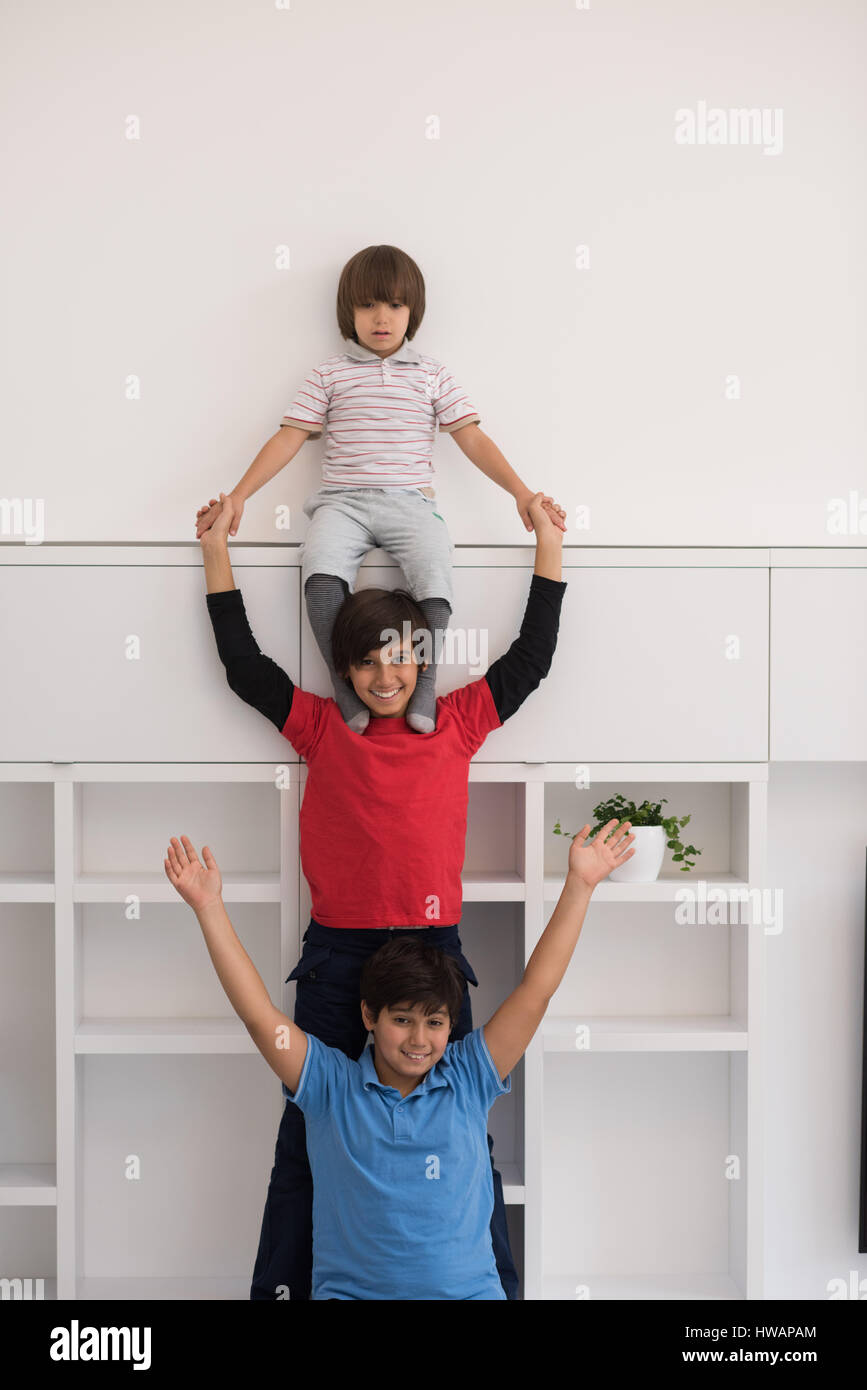 happy young boys having fun and posing line up piggyback in new modern ...