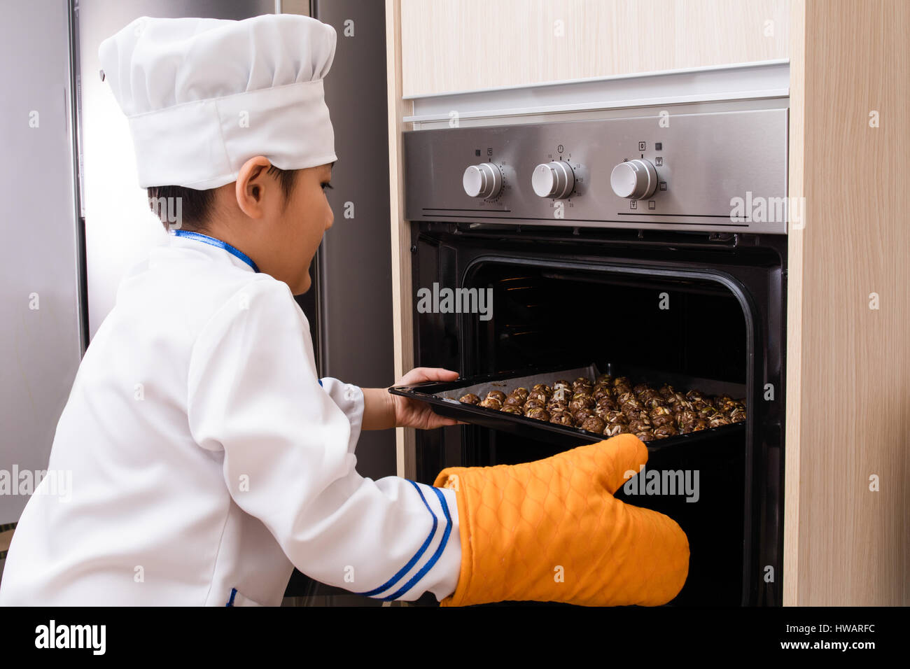 Asian Chinese Boy in white chef uniform Baking Cookies at Home Stock ...