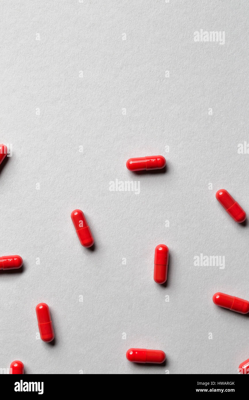 red medicine capsules on grey paper background, top view Stock Photo ...