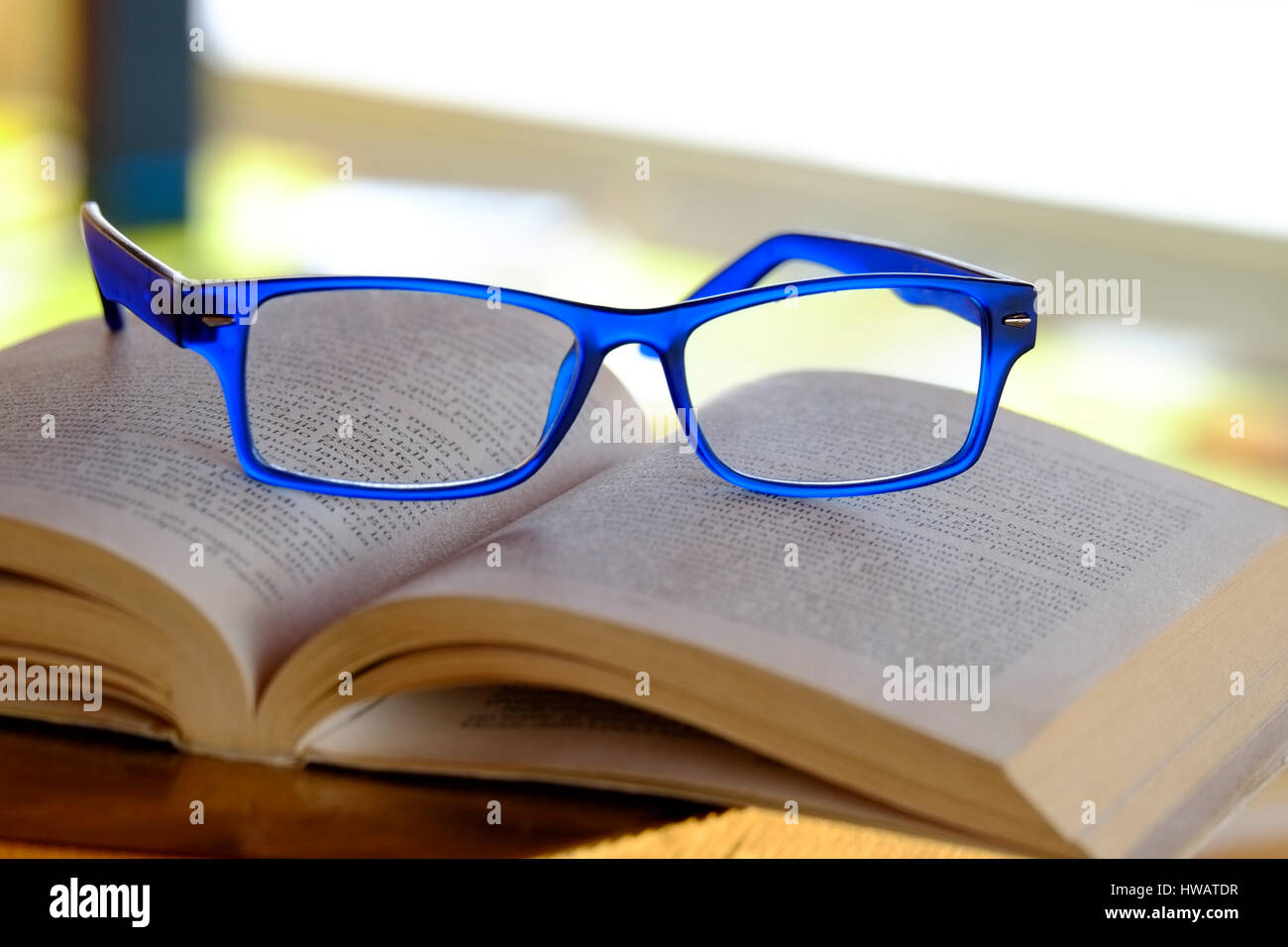 Blue Glasses Resting on Stack of Books and Magazines Stock Photo - Alamy