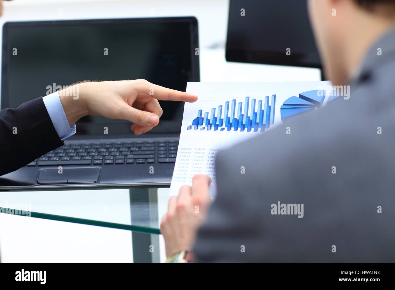 Young businessman hand pointing at graph document during discussion at ...