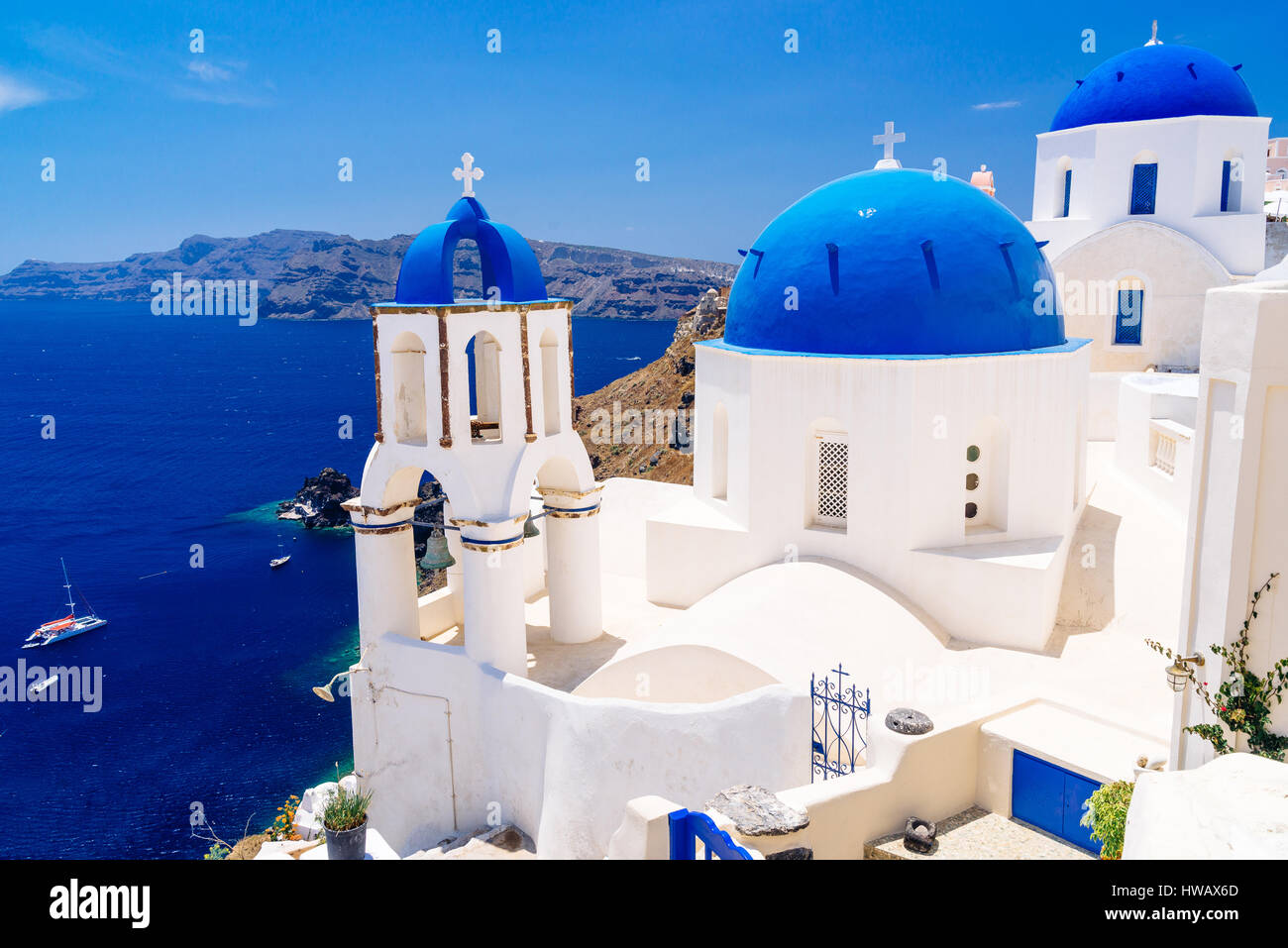 White architecture and churches with blue domes, Oia, Santorini, Greece ...