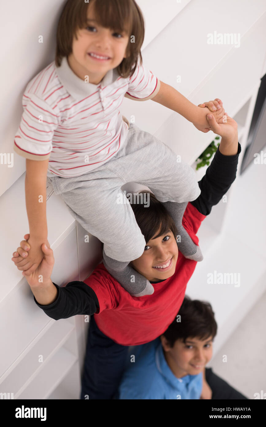 happy young boys having fun and posing line up piggyback in new modern ...