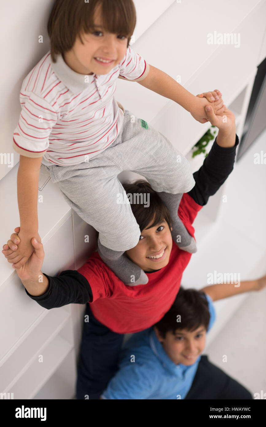 happy young boys having fun and posing line up piggyback in new modern ...