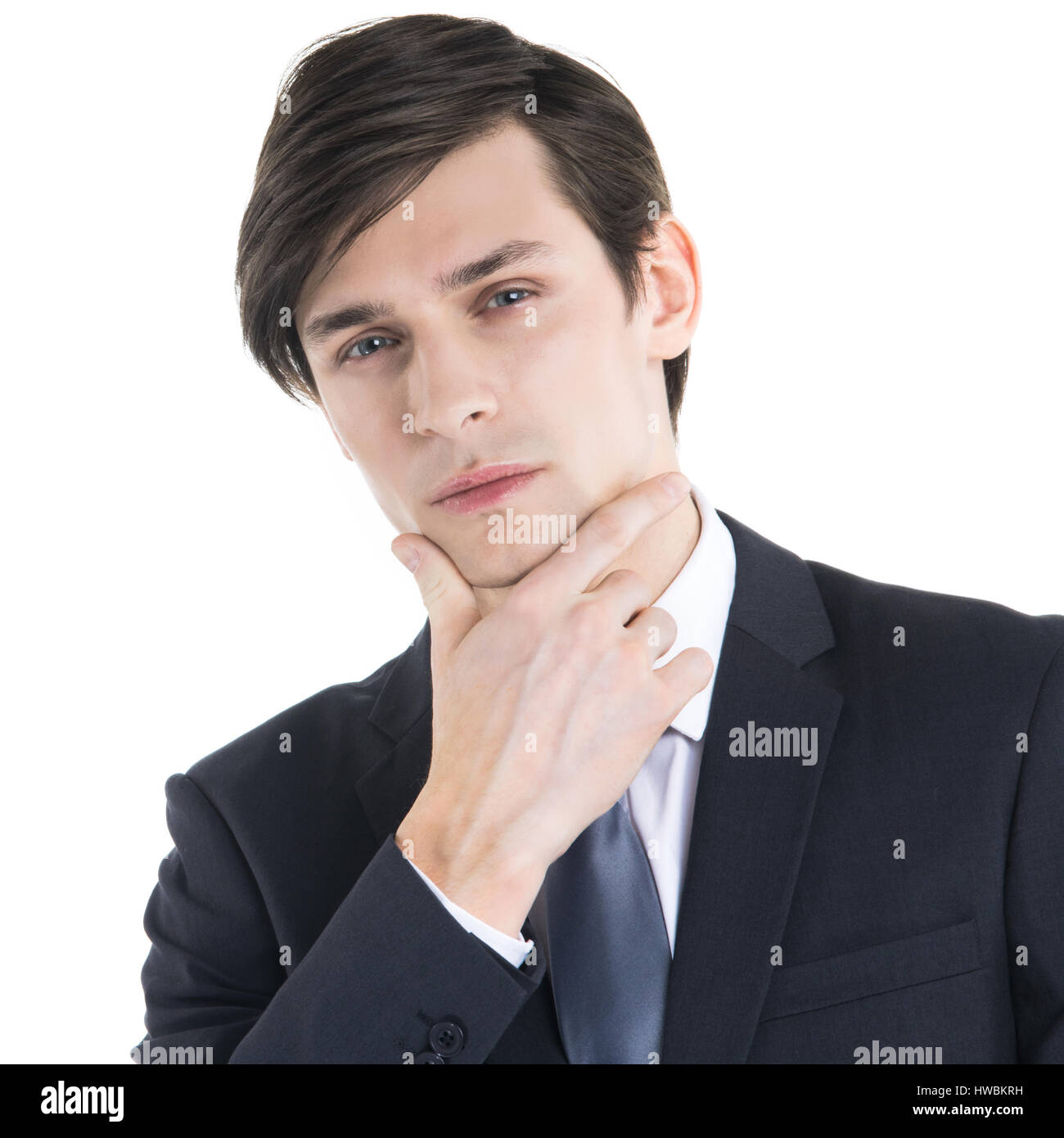 Portrait young business man holding hand in his chin while looking ...