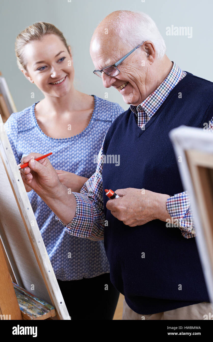 Senior Man Attending Painting Class With Teacher Stock Photo - Alamy