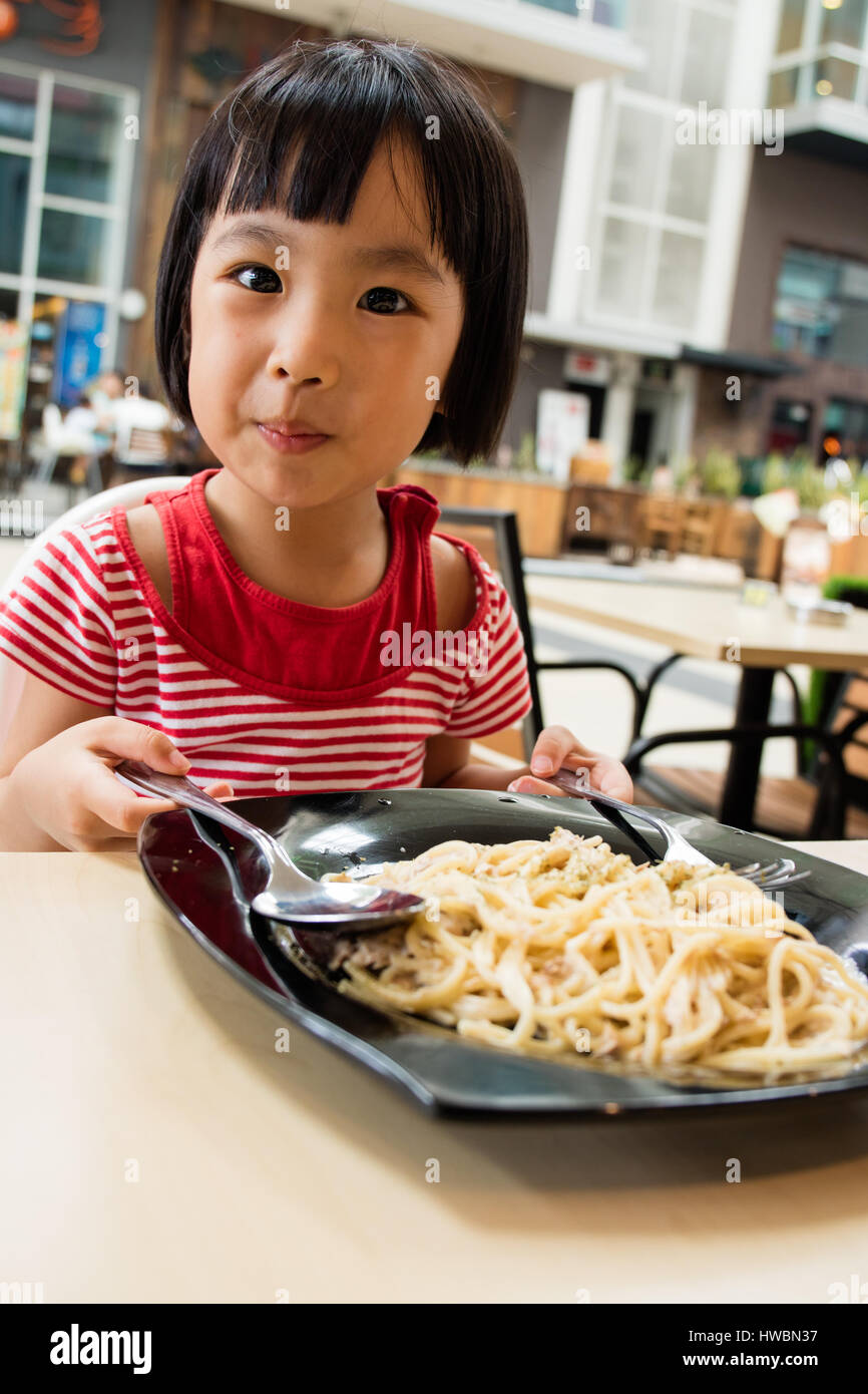 Asian Little Chinese Girl Eating spaghetti in Outdoor Cafe Stock Photo ...