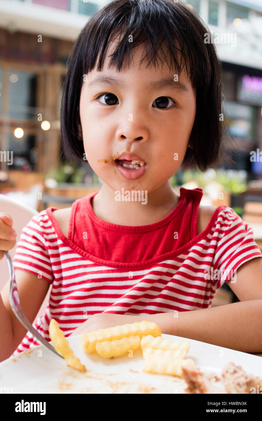 Asian Little Chinese Girl Eating French Fries in Outdoor Cafe Stock ...