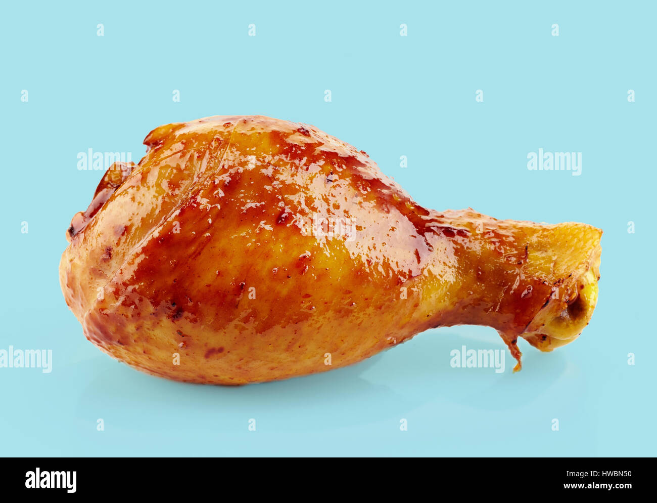 Roasted chicken leg on a blue background Stock Photo - Alamy