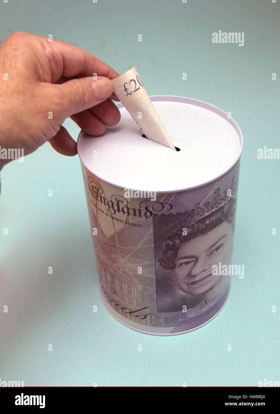 Placing banknote in money box, London Stock Photo - Alamy