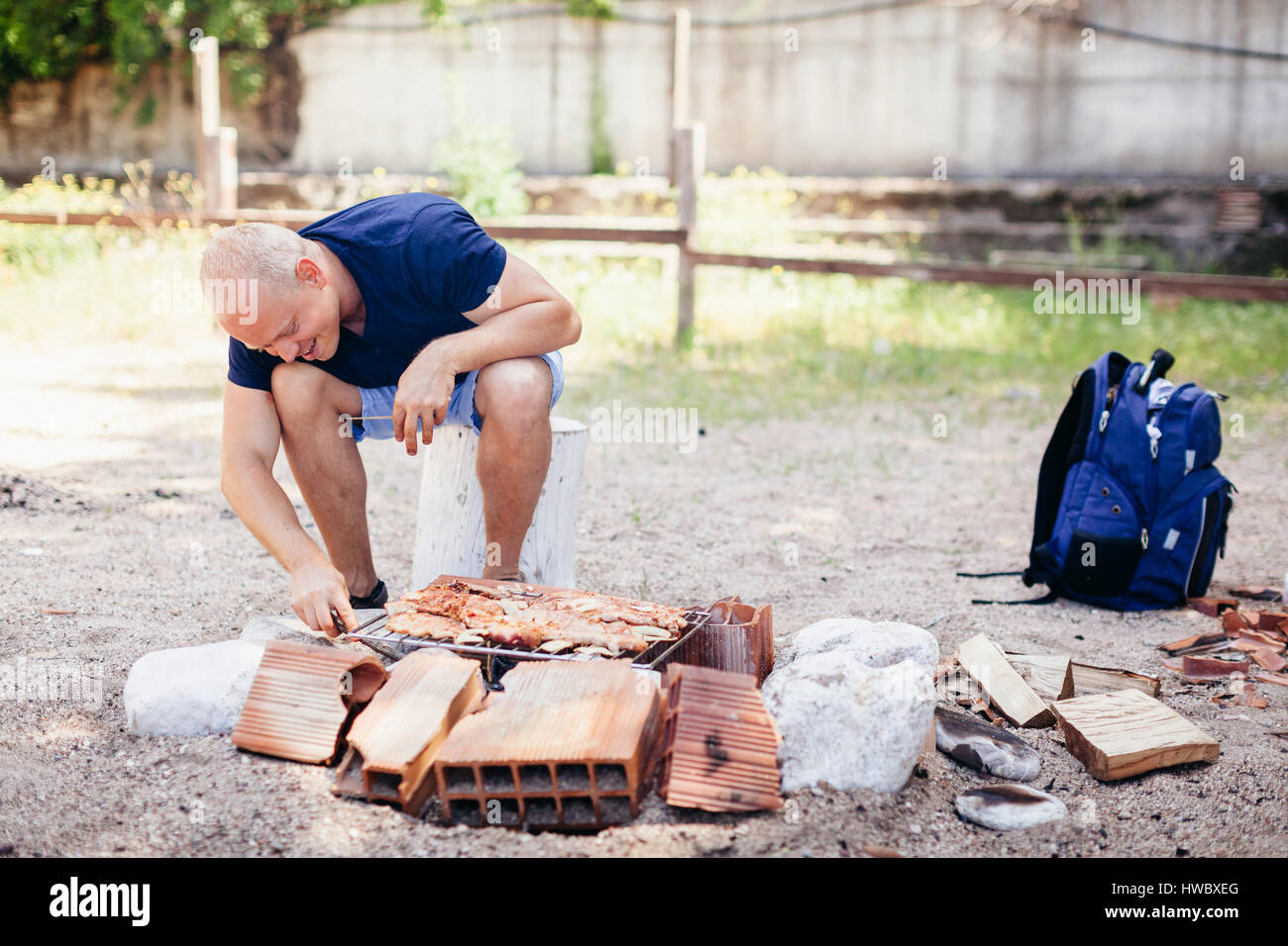 man cooking bbq in forest green park Stock Photo - Alamy