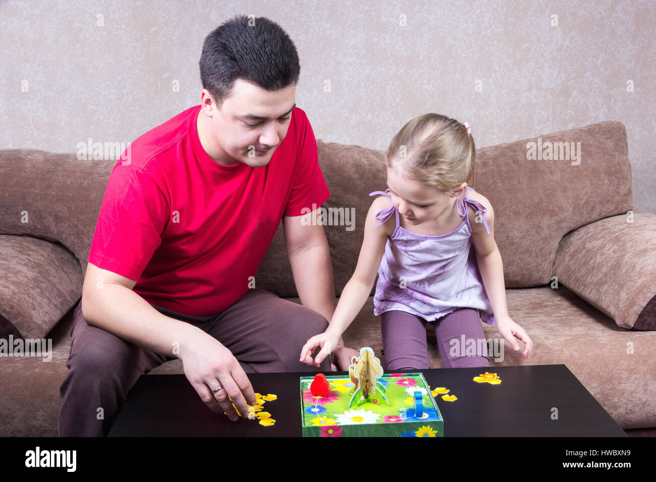 Dad and daughter are playing table game Stock Photo - Alamy