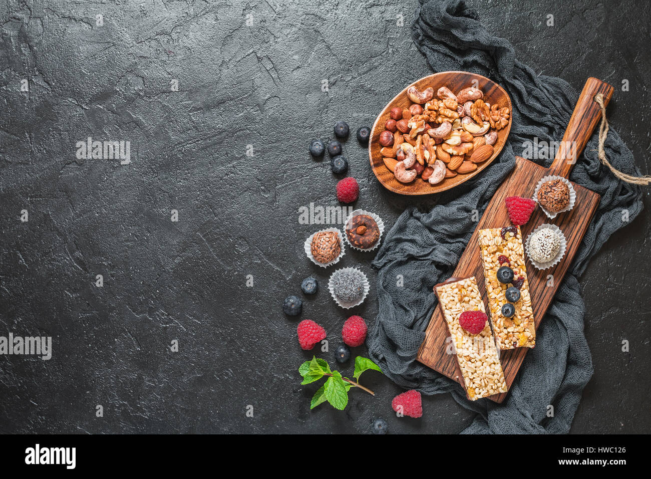 Energy bars and balls - snack for healthy lifestyle on black background ...