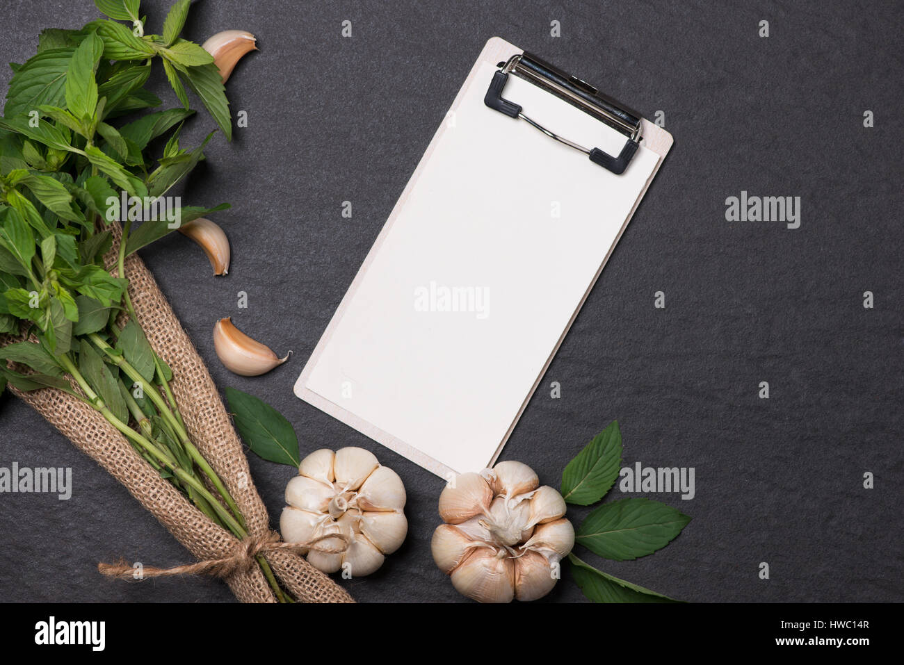 Vegetable recipe. Open menu book with fresh herbs and spices on dark ...