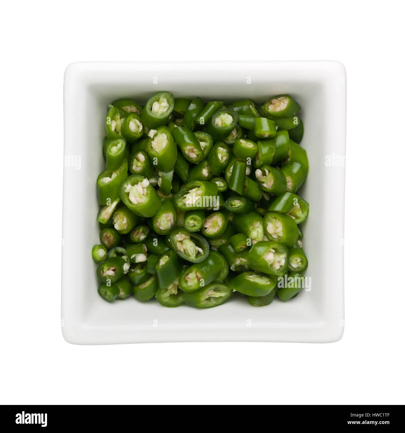 Sliced green chilli in a square bowl isolated on white background Stock ...