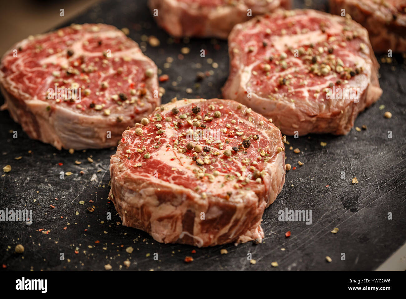 Raw meat steak on dark background ready to roast Stock Photo - Alamy