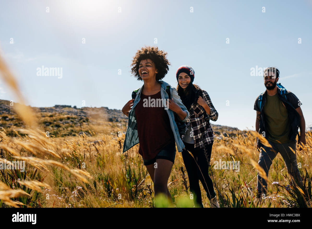 Group of friends on walk through countryside together. Happy young men ...