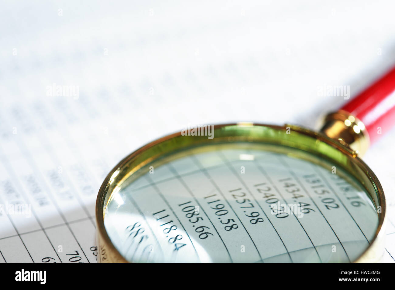 Closeup of magnifying glass on paper background with digits Stock Photo ...