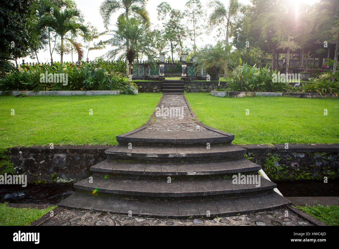 Stone path and steps in tropical gardens, a frontal view of the path of ...