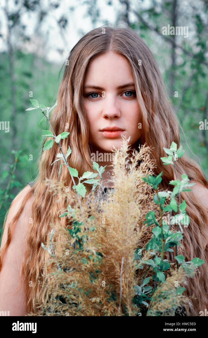 Portrait of spring girl in green trees,flowers,garden,park.Long-haired ...