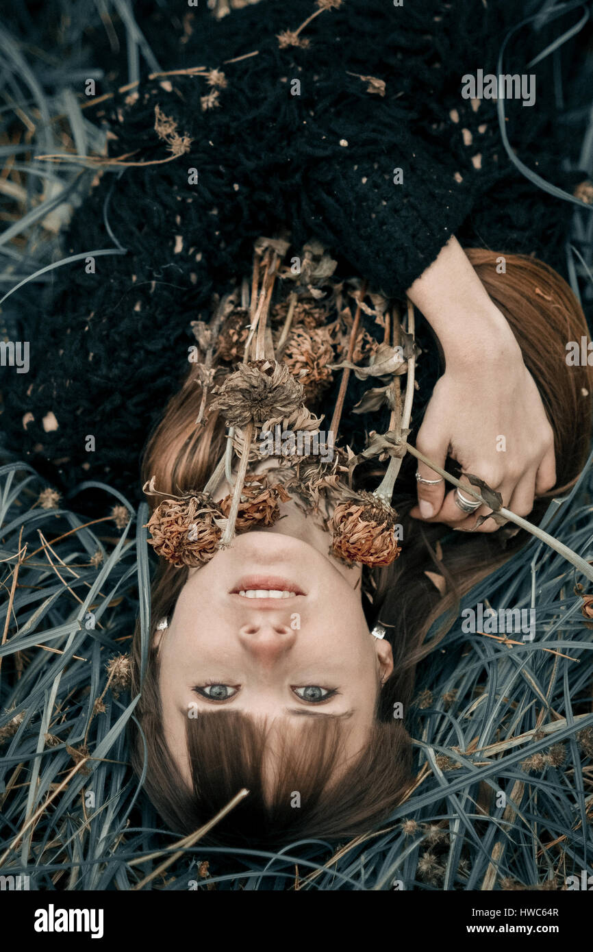 Pretty girl lay on green grass and hug flowers Stock Photo - Alamy