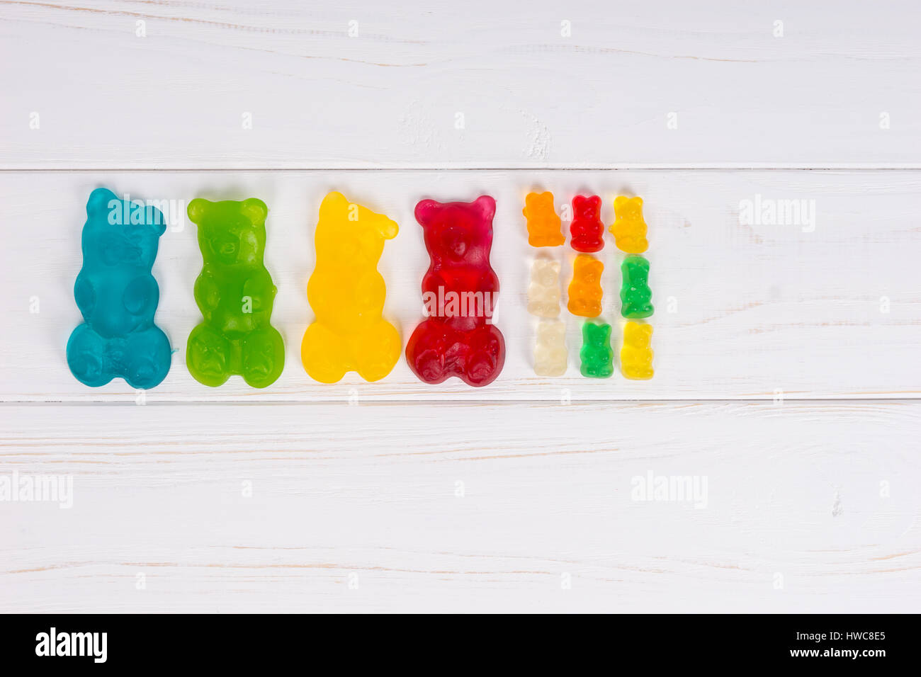 Candies in the form of a multicolored big and small gummy bears on ...