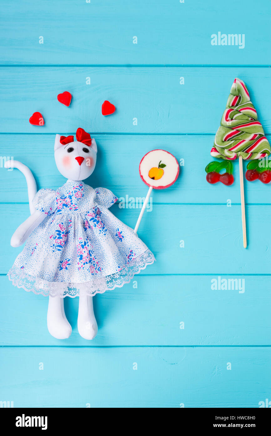 Homemade toy in the form of a cat with gummy hearts around holding ...