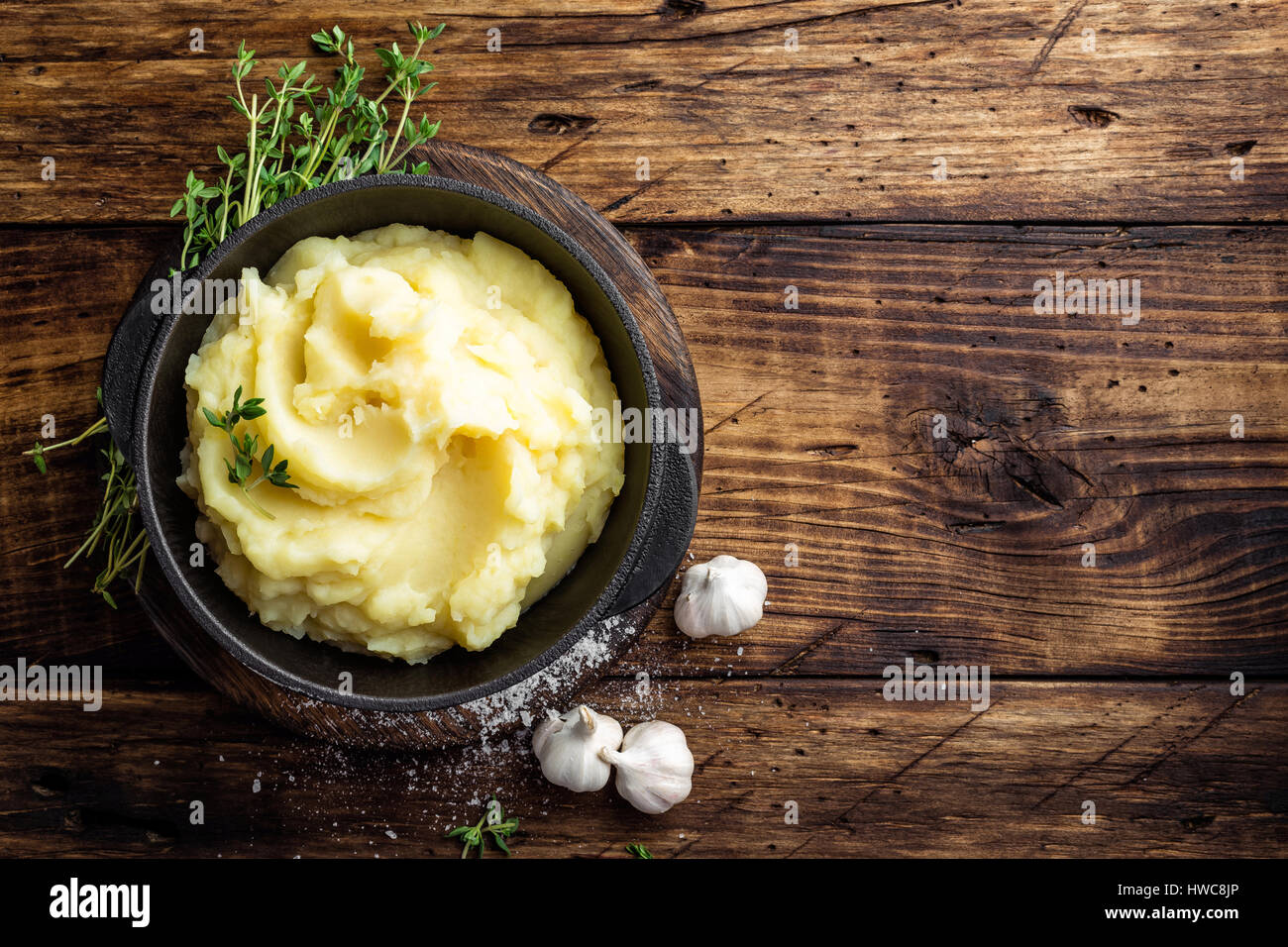 Mashed potatoes, boiled puree in cast iron pot on dark wooden rustic ...
