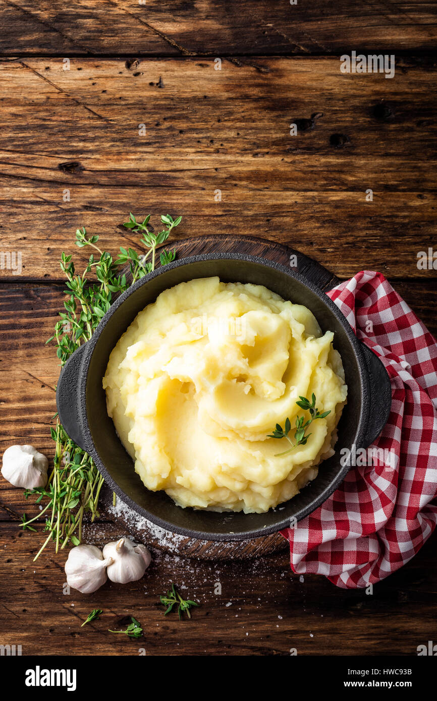 Mashed potatoes, boiled puree in cast iron pot on dark wooden rustic ...