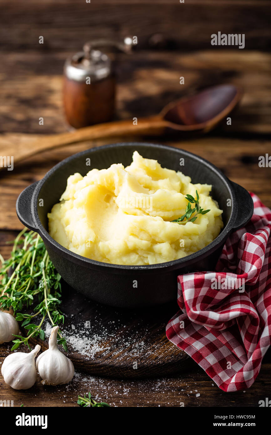 Mashed potatoes, boiled puree in cast iron pot on dark wooden rustic ...