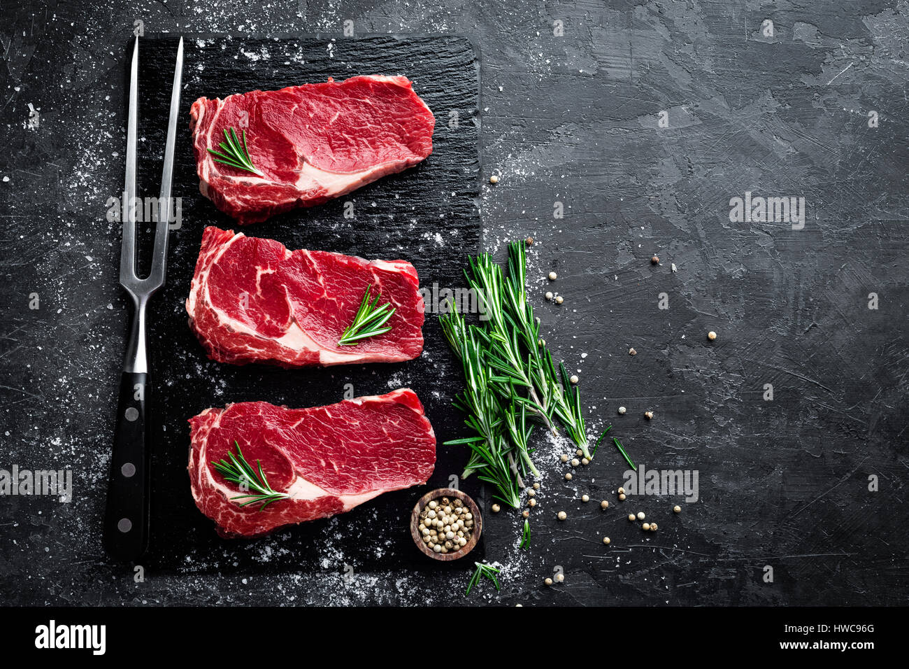 Raw meat, beef steak on black background, top view Stock Photo - Alamy