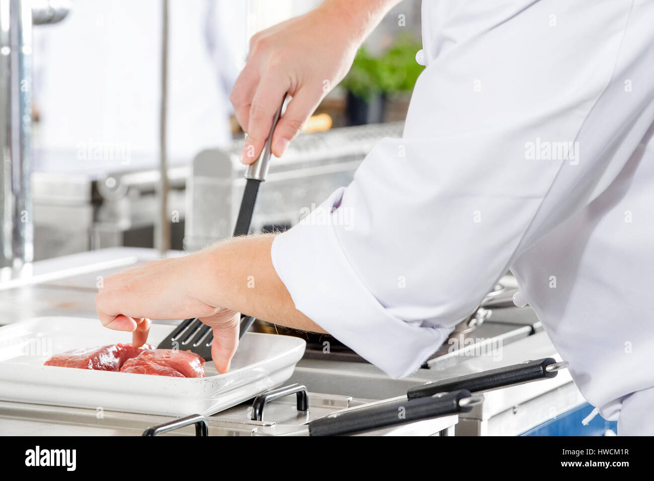 Close-up of a chef prepares beef steak in pan at the kitchen Stock ...